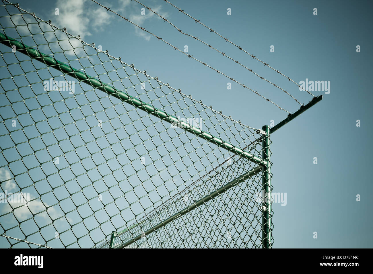 A chain link fence, topped by razor wire. Horizontal shot Stock Photo ...