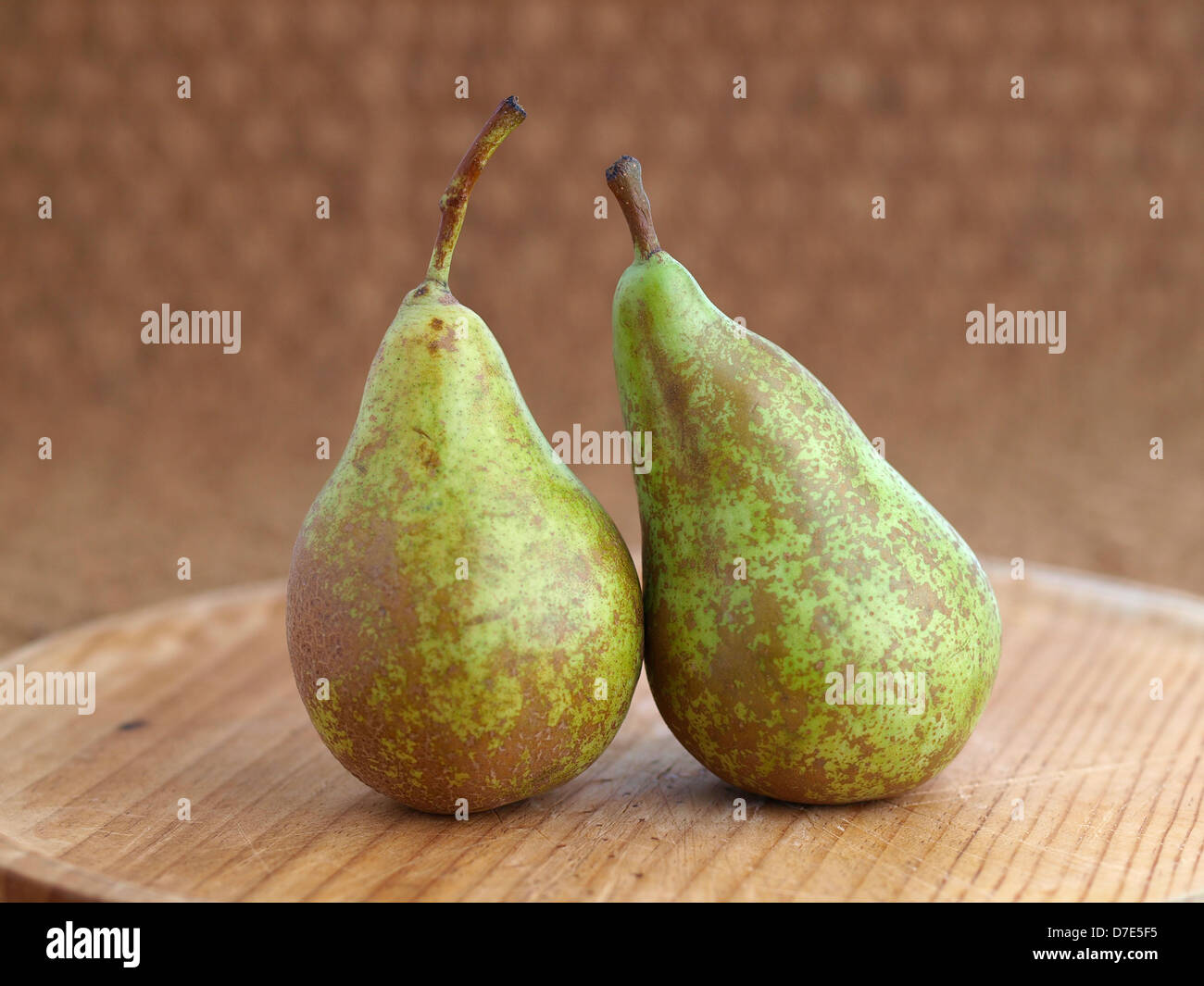 Two green pears on a wooden plate Stock Photo - Alamy