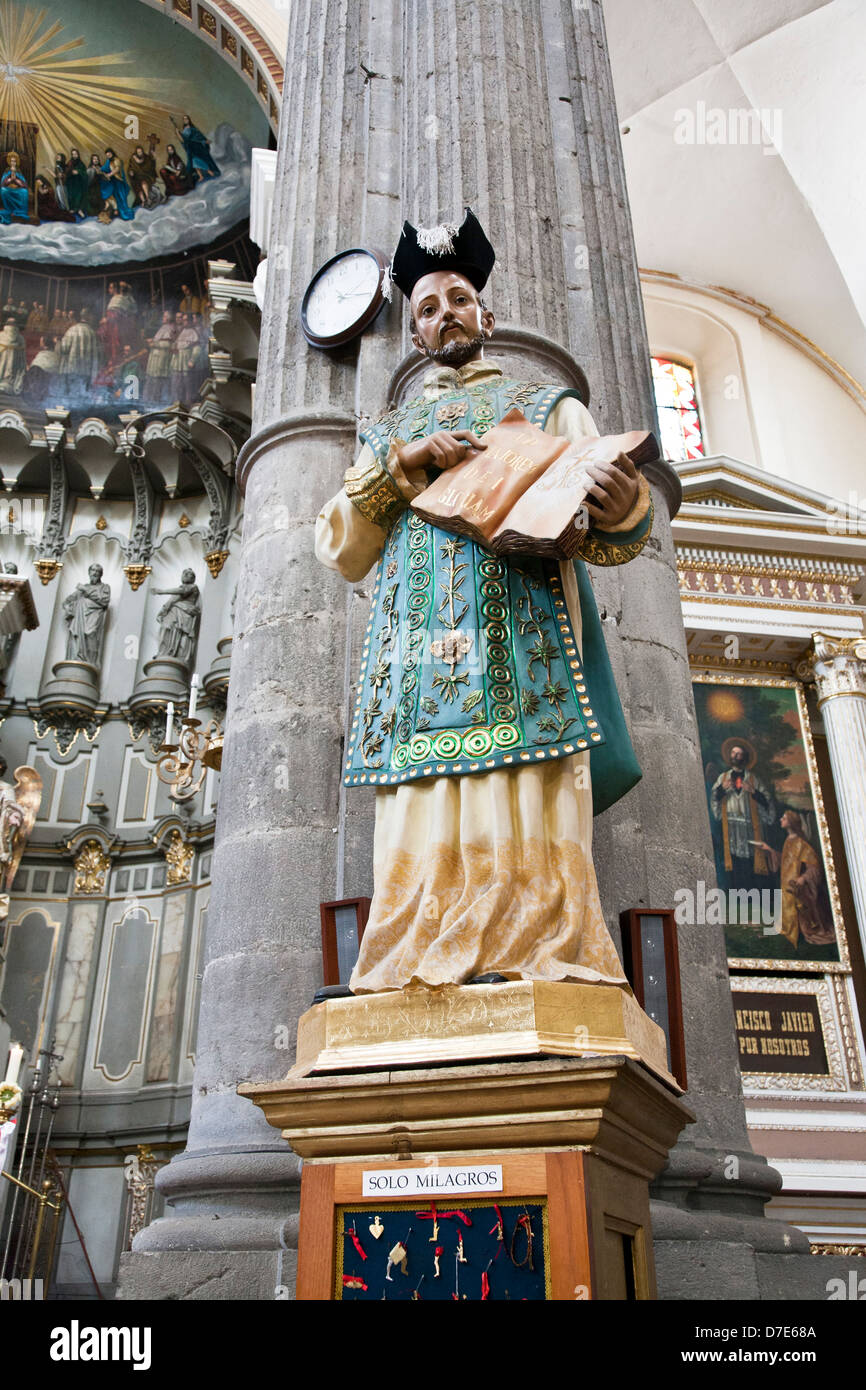 polychrome statue of a bishop holding open a book inscribed with Jesuit ...