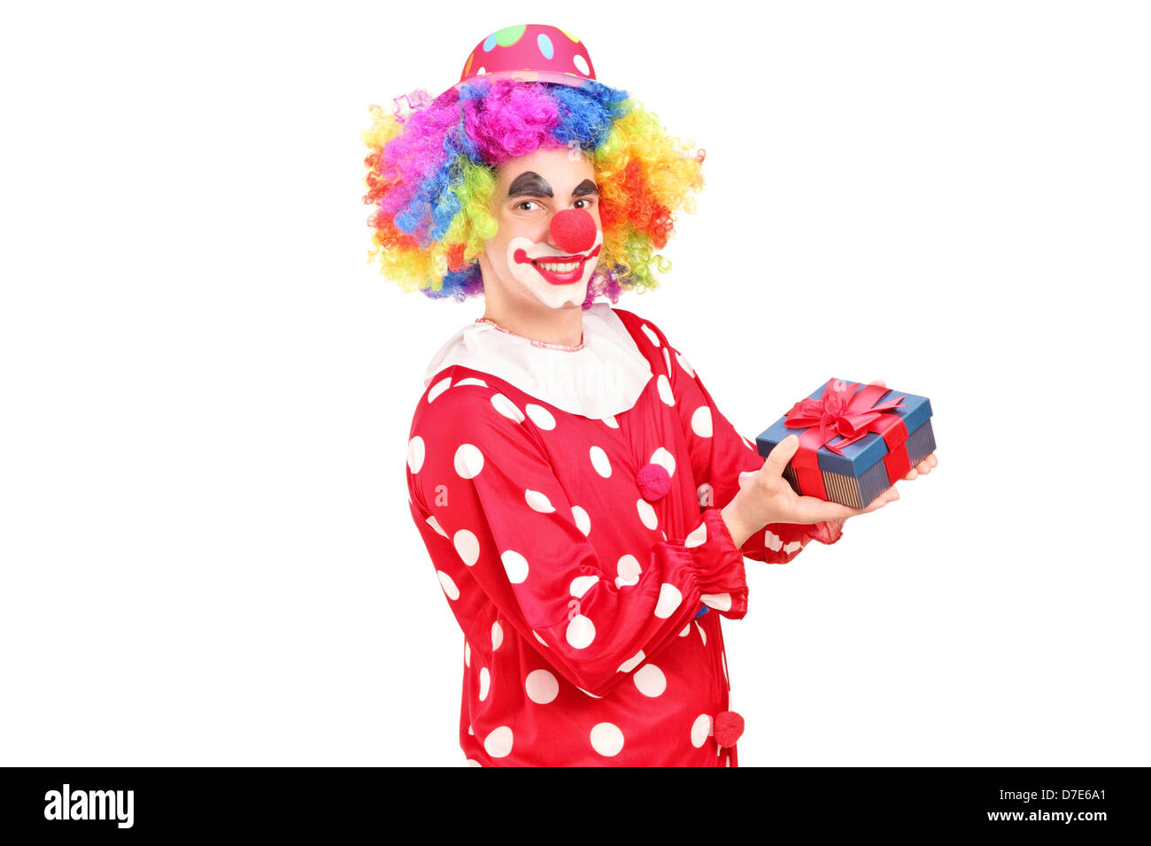 A male clown with joyful expression on his face holding a gift isolated ...