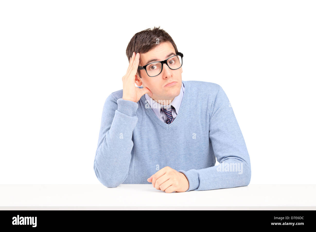 Doubtful guy sitting and thinking on a table isolated on white ...