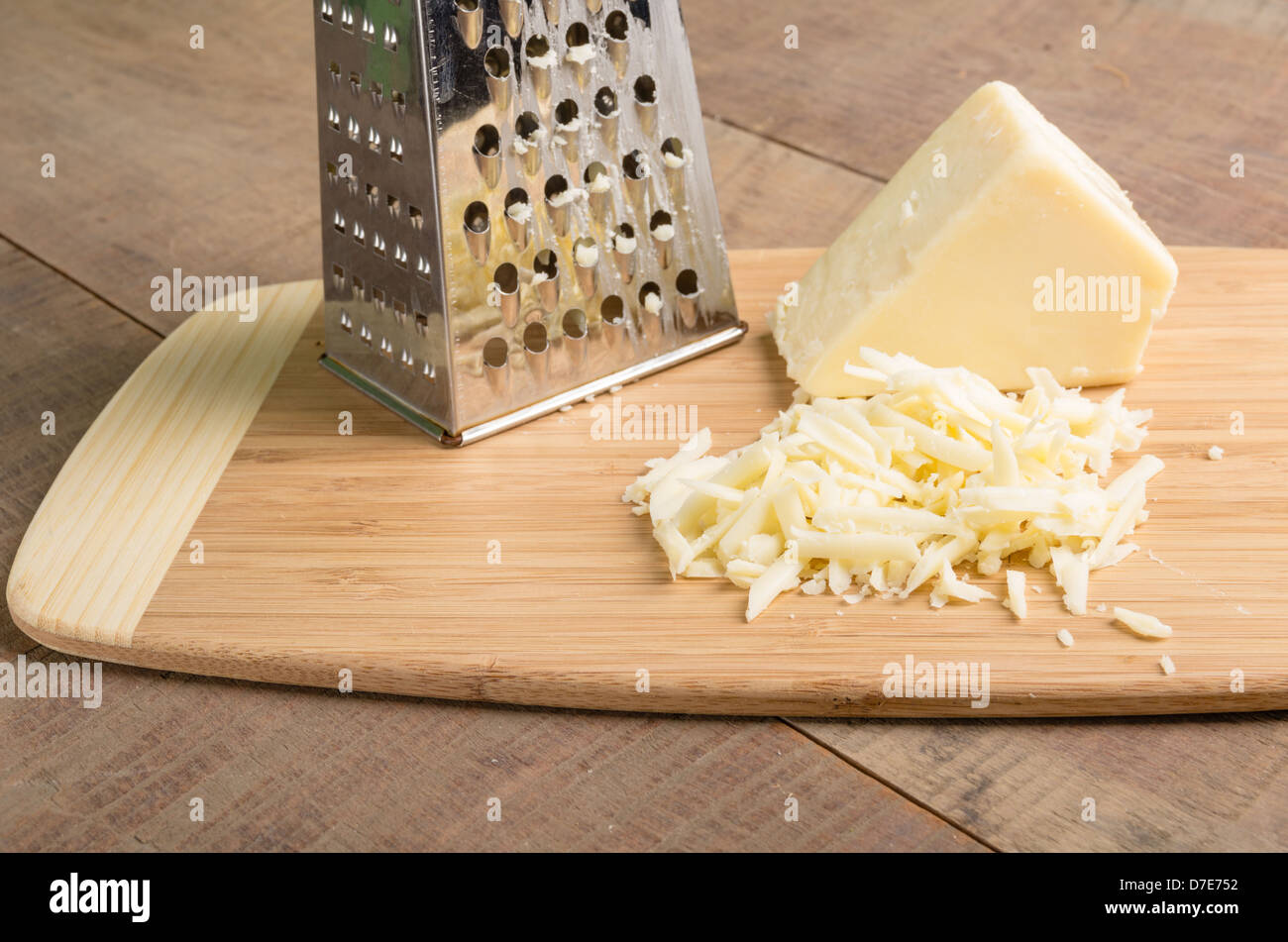 Fresh Parmesan cheese with a metal grater on a cutting board Stock ...