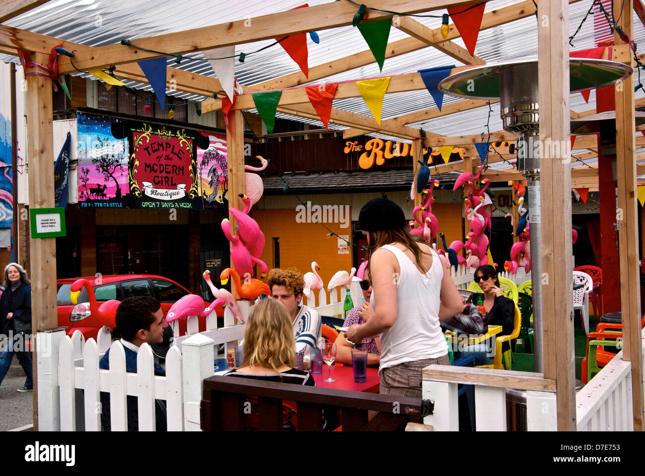 Waitress taking orders from customers seated at rustic covered patio ...