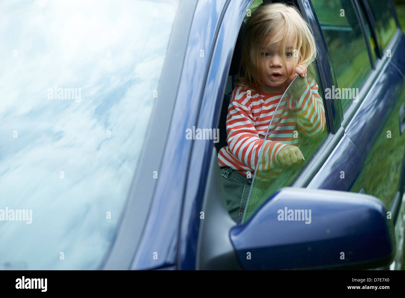 Little blond girl child playing inside a car Stock Photo - Alamy