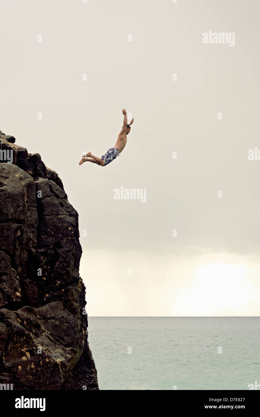 man jumping off a cliff into the ocean off of "da big rock" on oahu ...