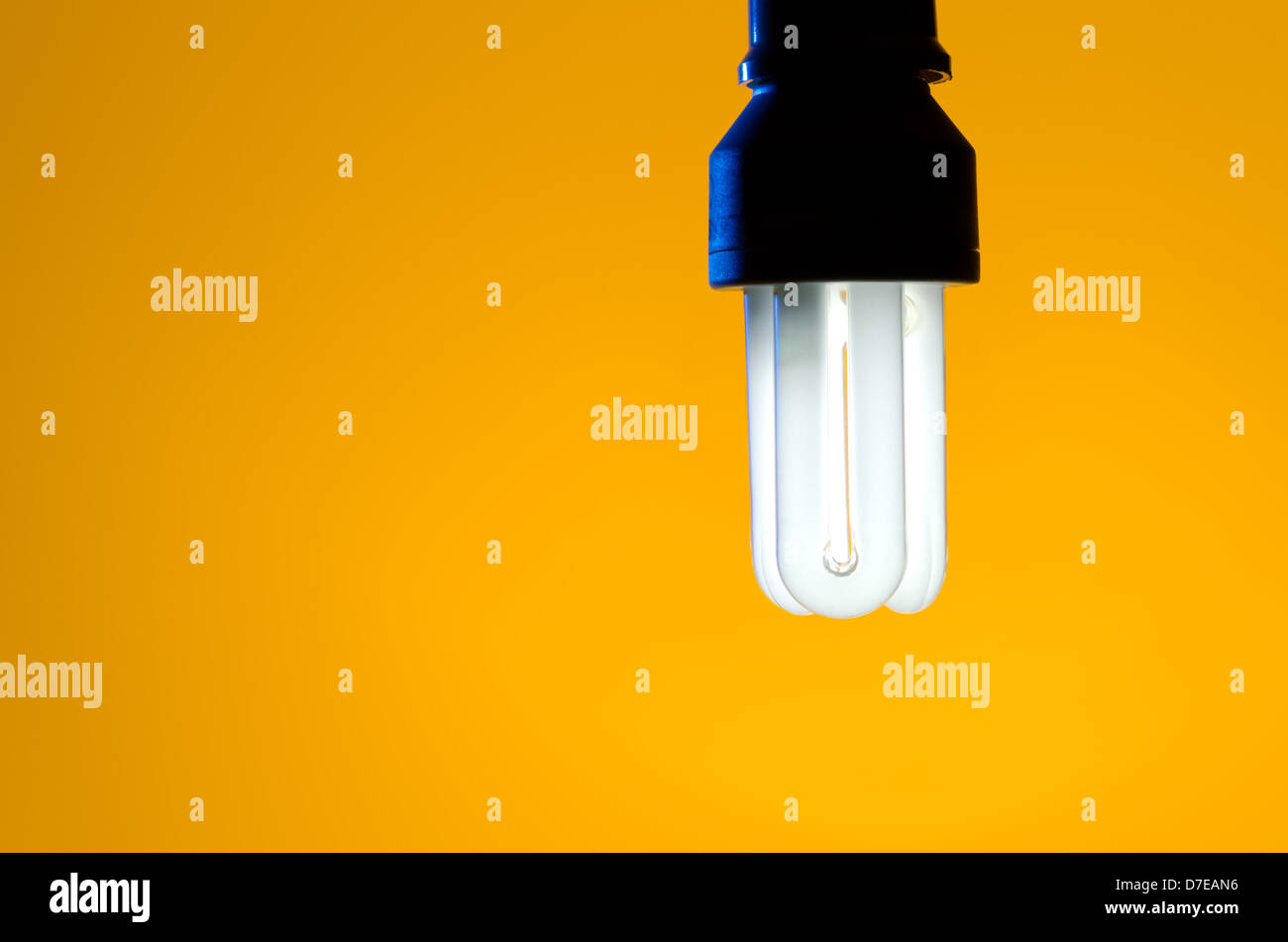 An energy saving light bulb on a yellow background Stock Photo - Alamy