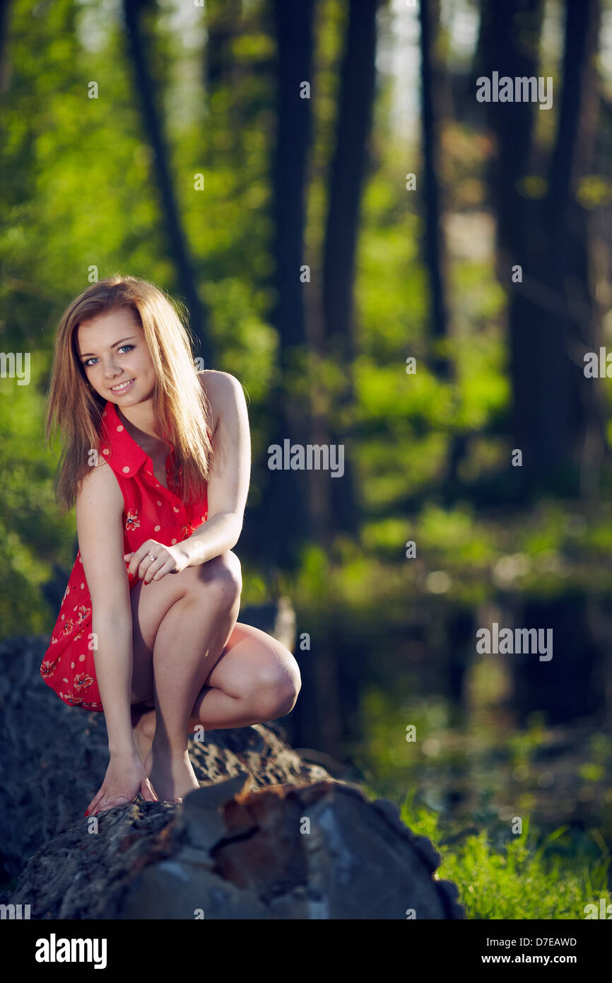 Girl siting on a log Stock Photo - Alamy