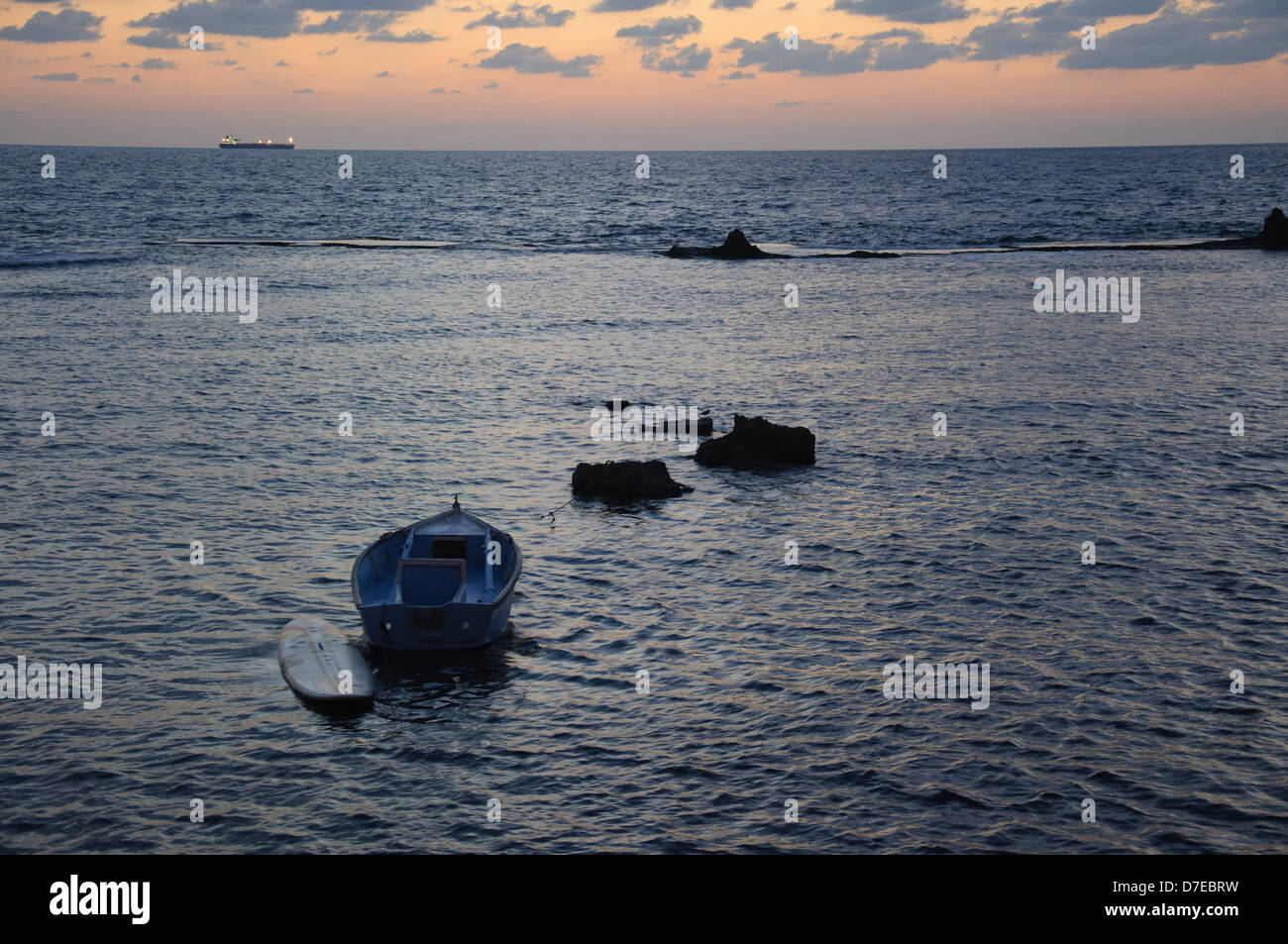A boat and rocks. Dusk Stock Photo - Alamy