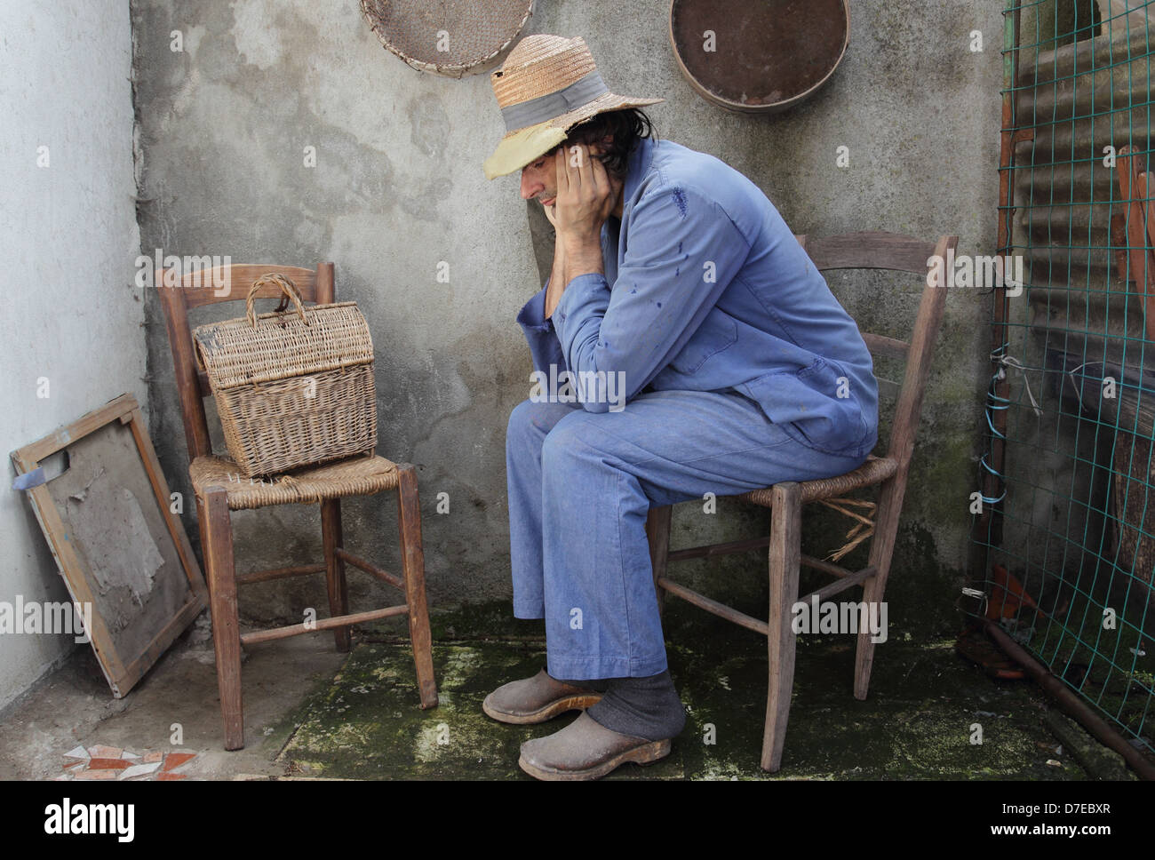 pensative poor peasant sititng on a chair Stock Photo - Alamy
