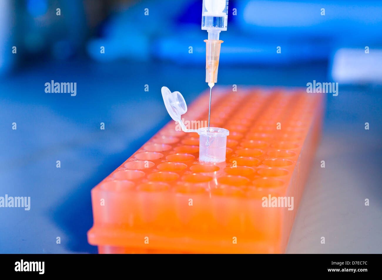 Syringe pouring liquid into test tube in plastic orange container Stock ...