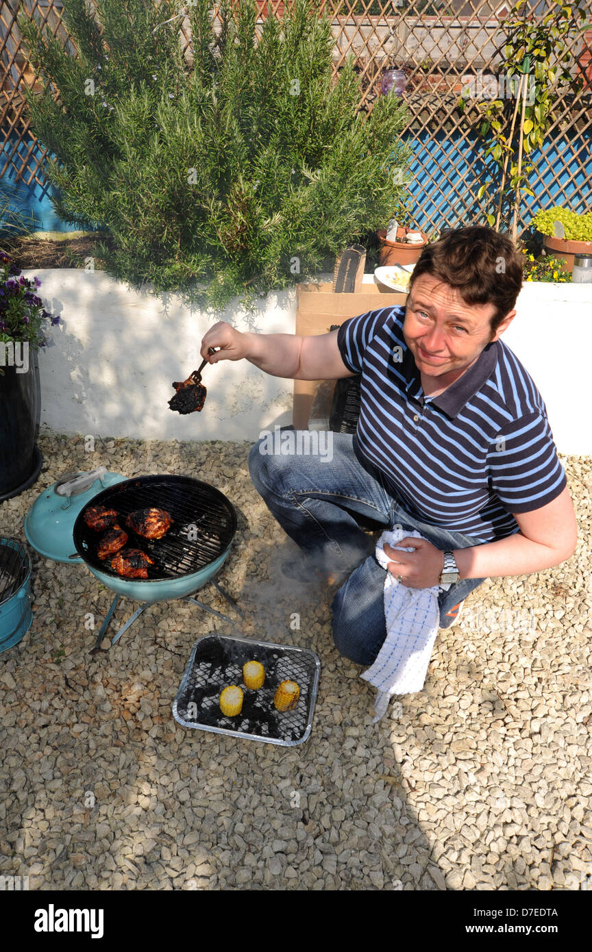 Woman cooking charcoal barbecue BBQ chicken cooking with burnt skin ...