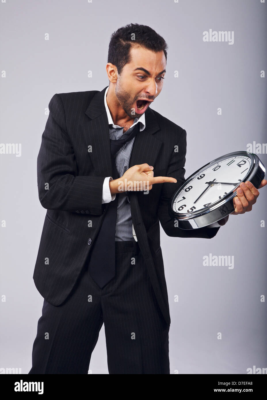 Angry businessman shouting and pointing to a clock Stock Photo - Alamy