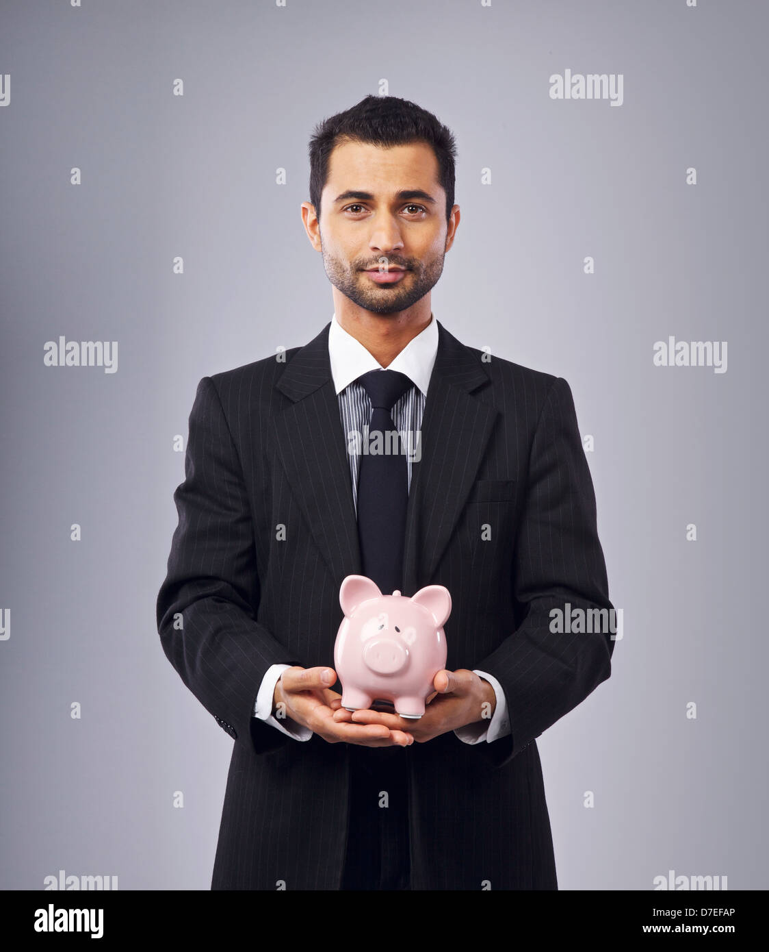 Corporate man holding a coin bank Stock Photo - Alamy
