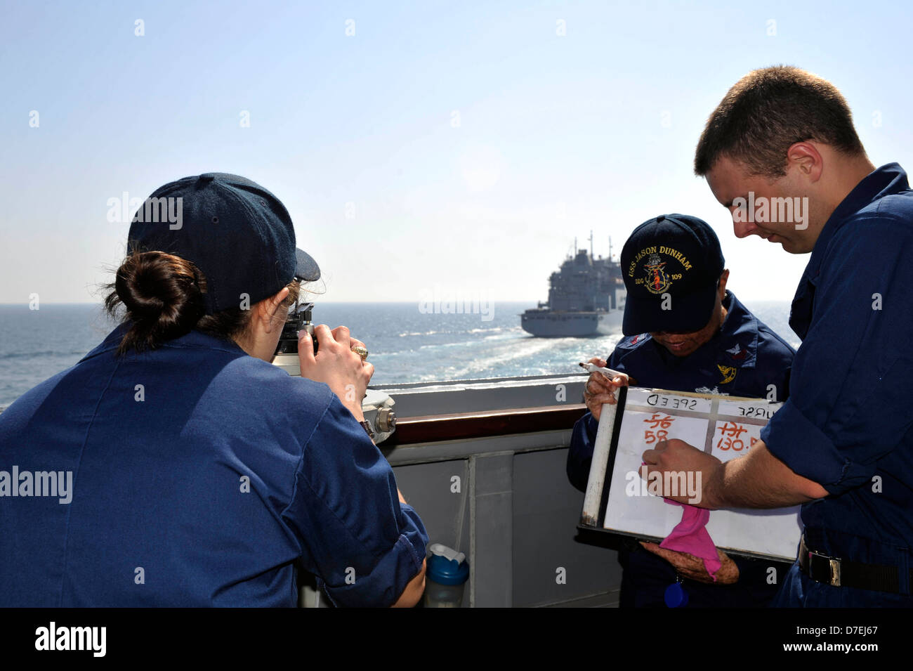 Sailors aboard USS Jason Dunham approach a resuply ship Stock Photo - Alamy