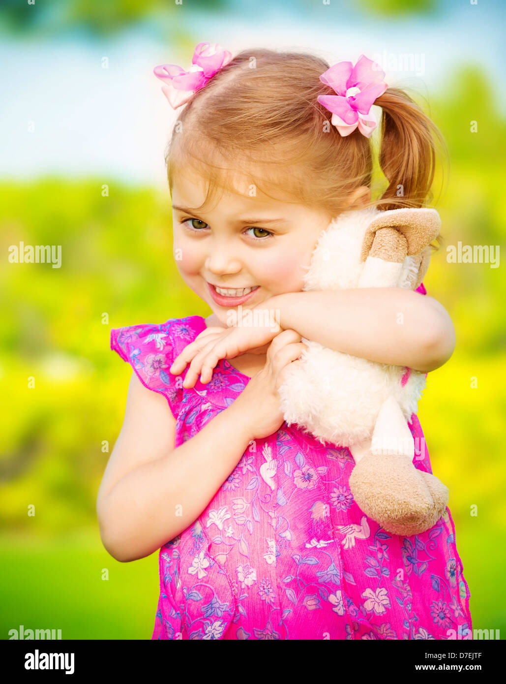 Closeup portrait of cute baby girl hugging soft toy outdoors, having ...
