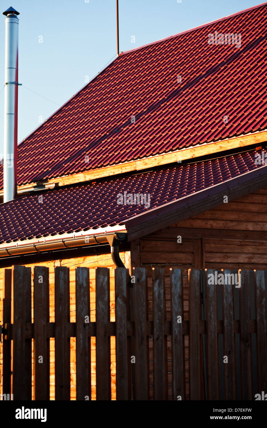 wood fence, chimney,red tile of new wooden house in country village ...