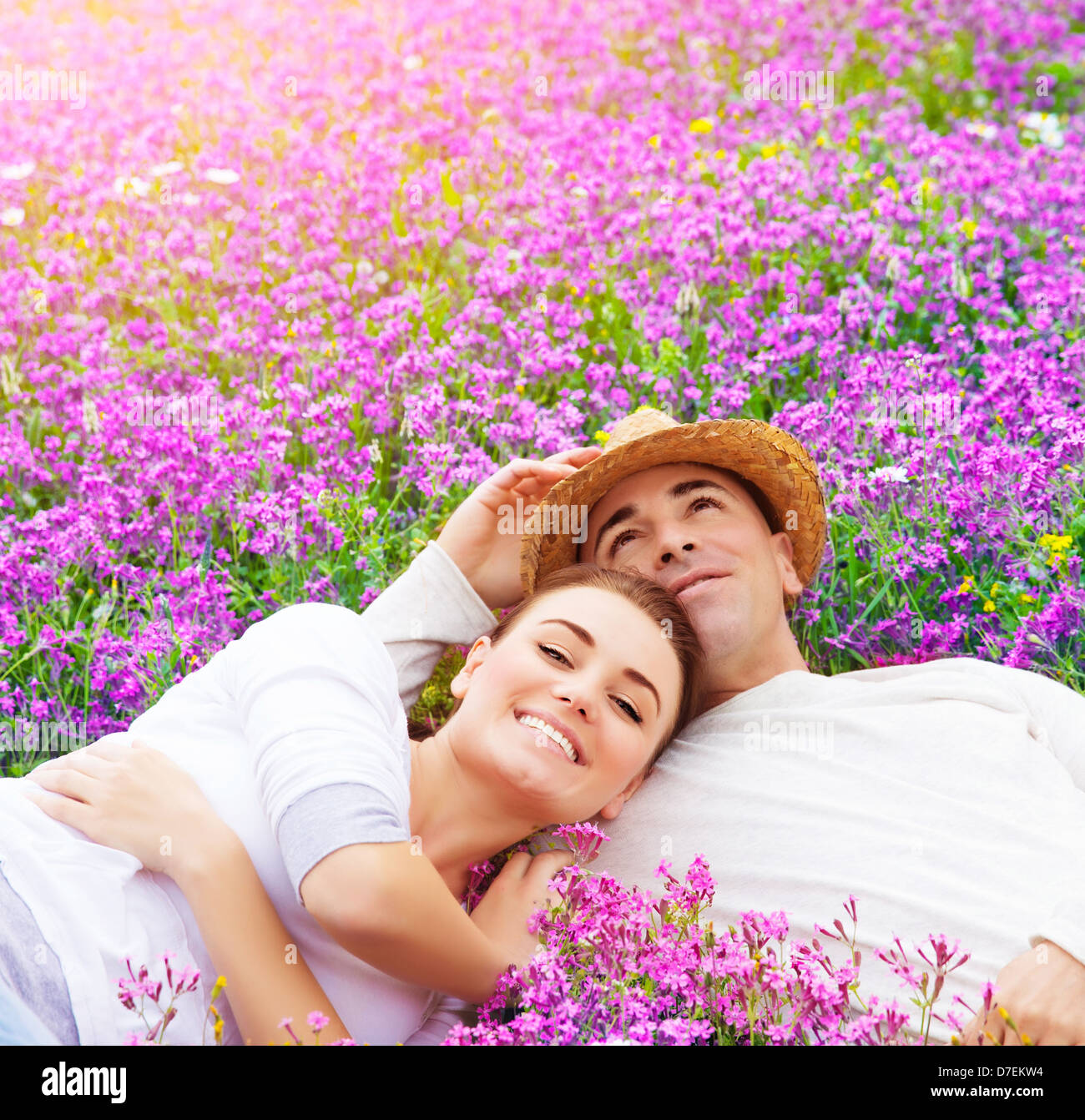 Young happy family laying down on fresh lavender meadow, hugging ...