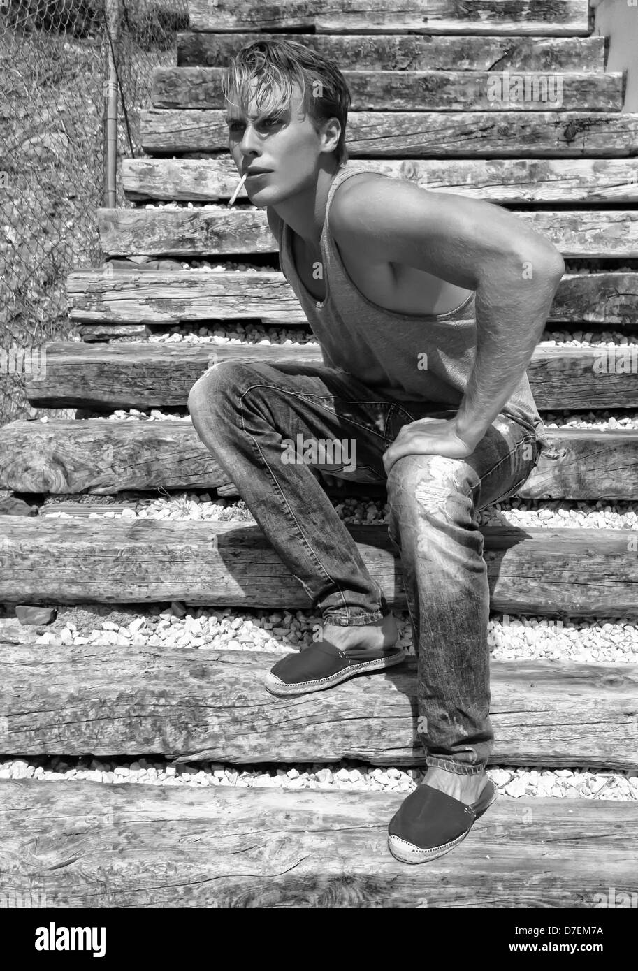 Young boy sitting on the steps smoking Stock Photo - Alamy