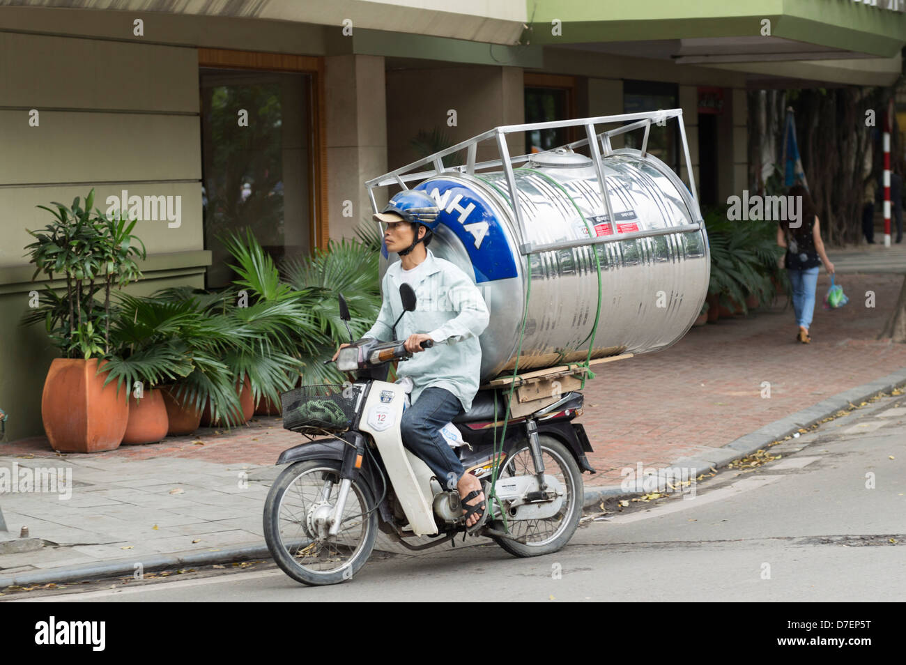Hanoi, Vietnam - man transporting a large water tank on the back of a ...