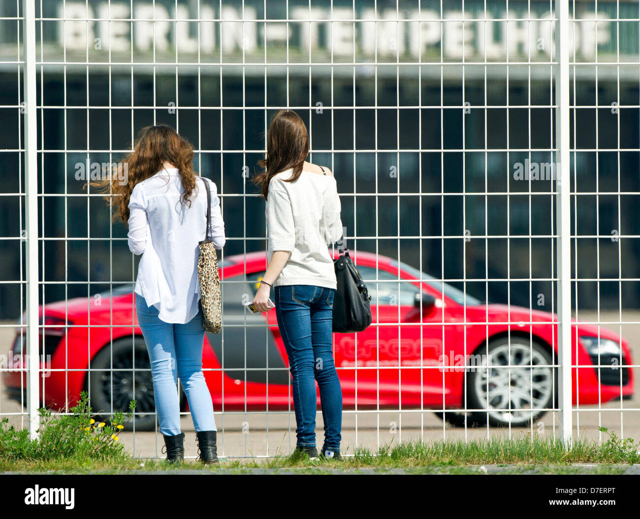 Two women watch an Audi R8 e-tron driv past them at Tempelhofer Feld in ...