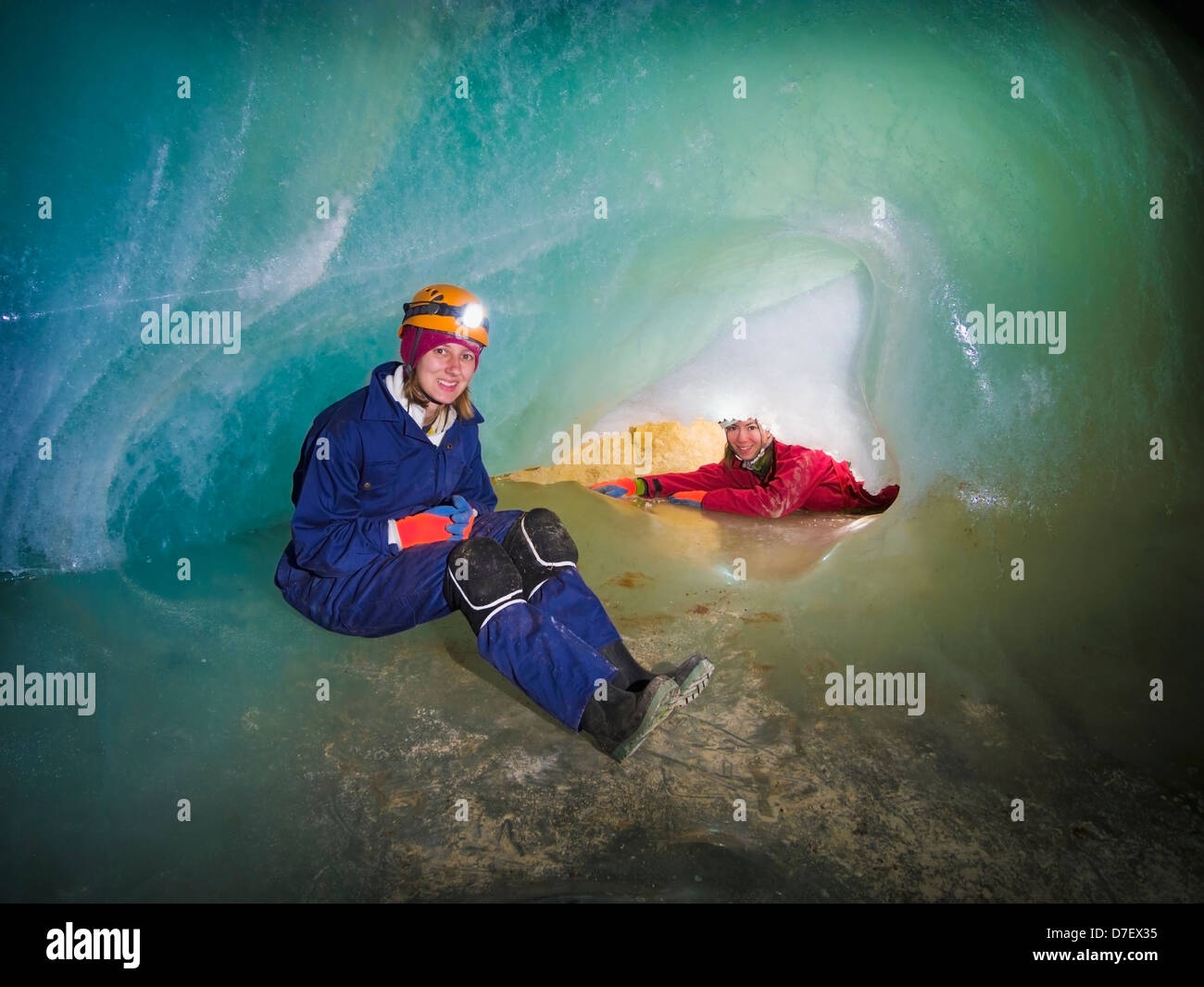 Two female cavers exploring a cave ice-plug;Crowsnest pass alberta ...