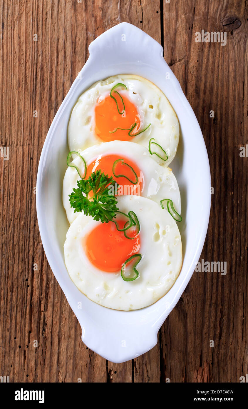 Fried eggs in a porcelain dish - overhead Stock Photo - Alamy