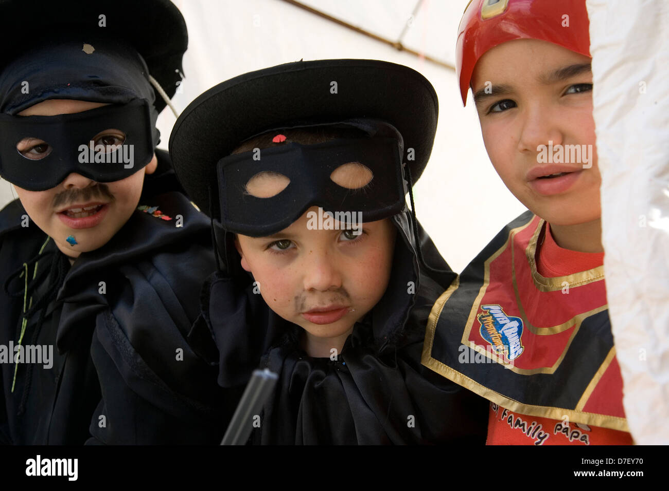 CHILDREN WEARING CARNIVAL MASKS AT A village fete in the Languedoc ...