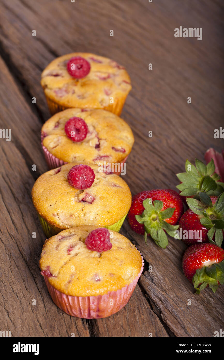 Four whole fruit muffins in a row on a old wooden board Stock Photo - Alamy