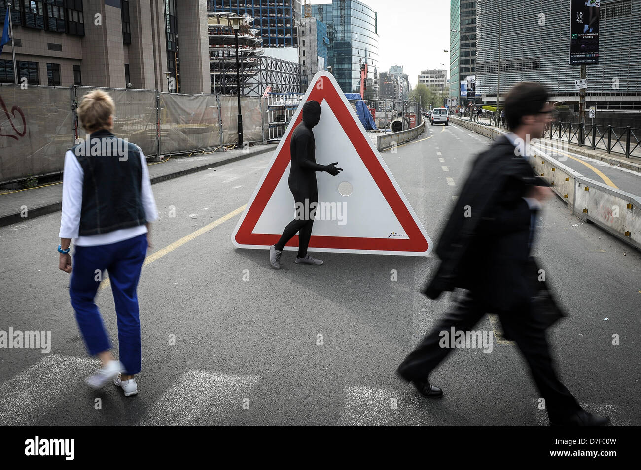 Dressed black man with the road sign on the street of Brussels, Belgium ...