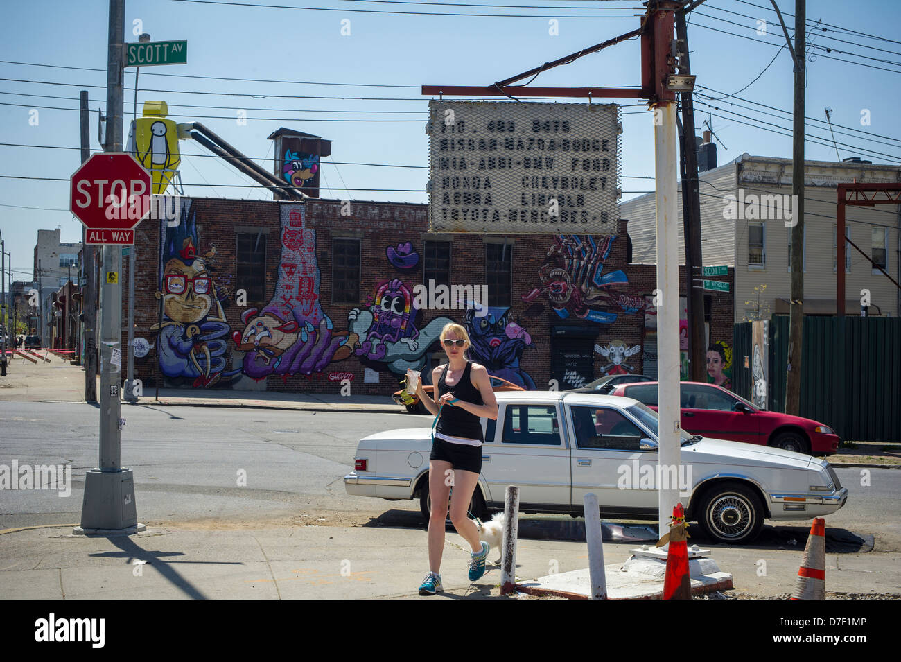 A woman walks a dog by the murals that grace the buildings in the so ...