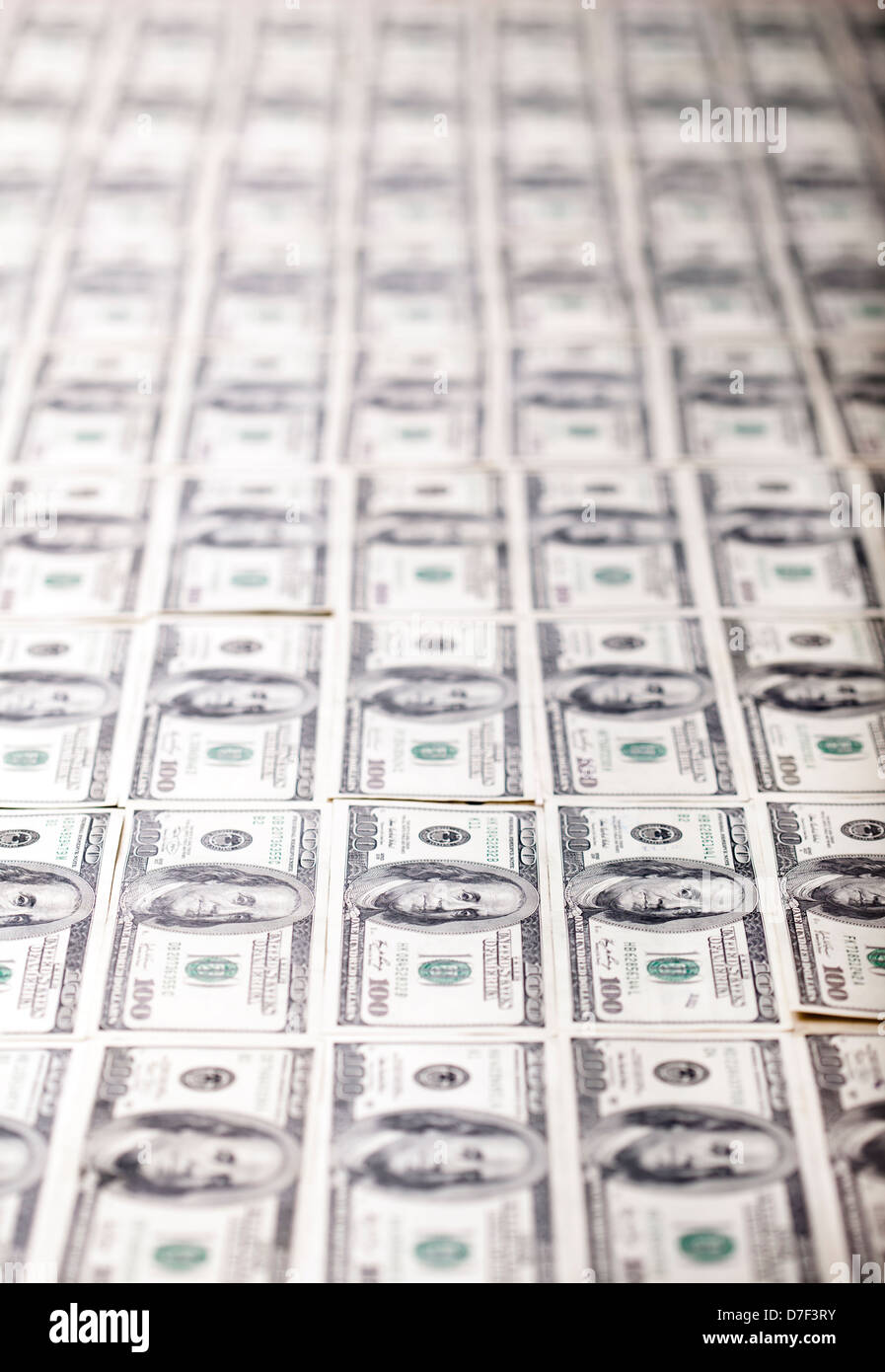 A large quantity of 100 US$ money notes lined up in rows. Very shallow ...