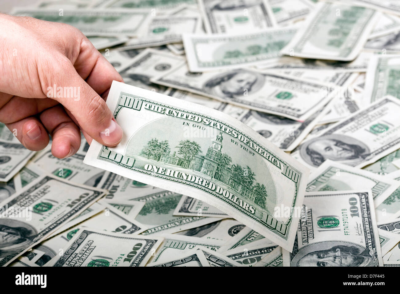The left hand an adult man holding 100 US$ money note very large amount ...