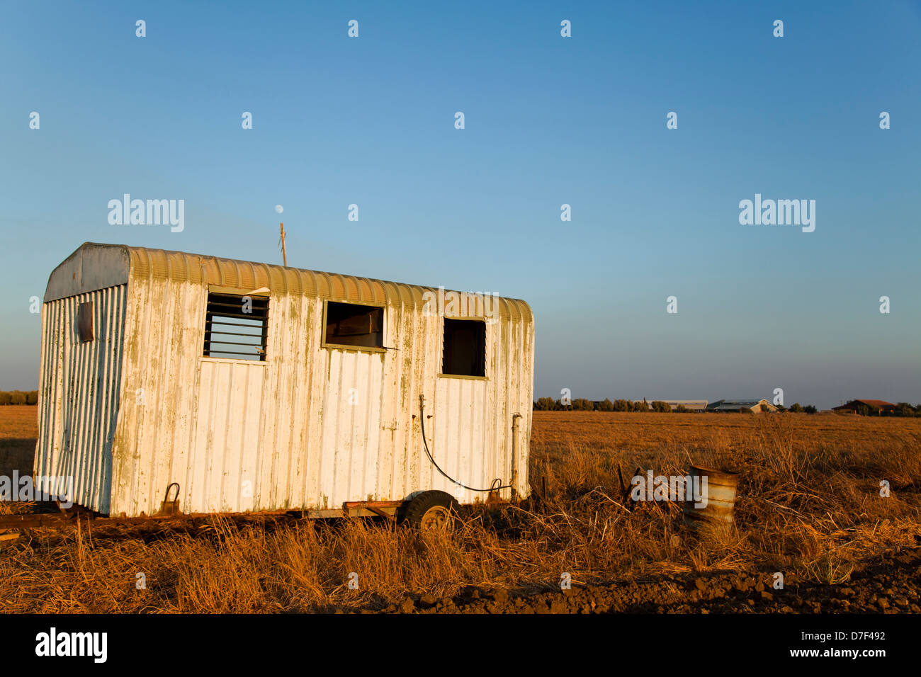 A deserted wreck an old beaten up trailer in middle harvested field in ...