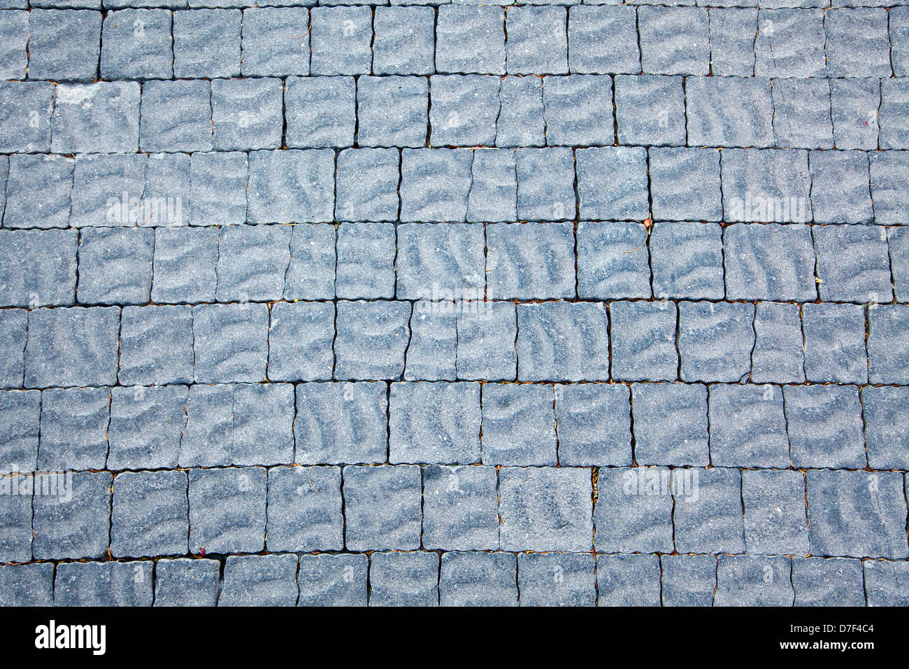 Gray floor tiles with wavy/rippled texture lit by diffused afternoon ...