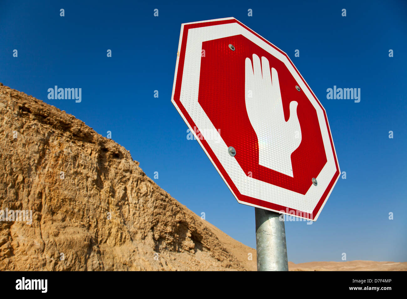 Stop sign on the background of a road and a desert mountain with clear ...