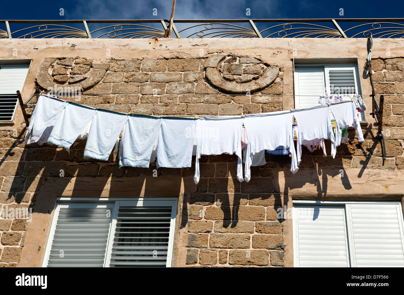 Low angle view of white laundry drying on the clothline under high-noon ...