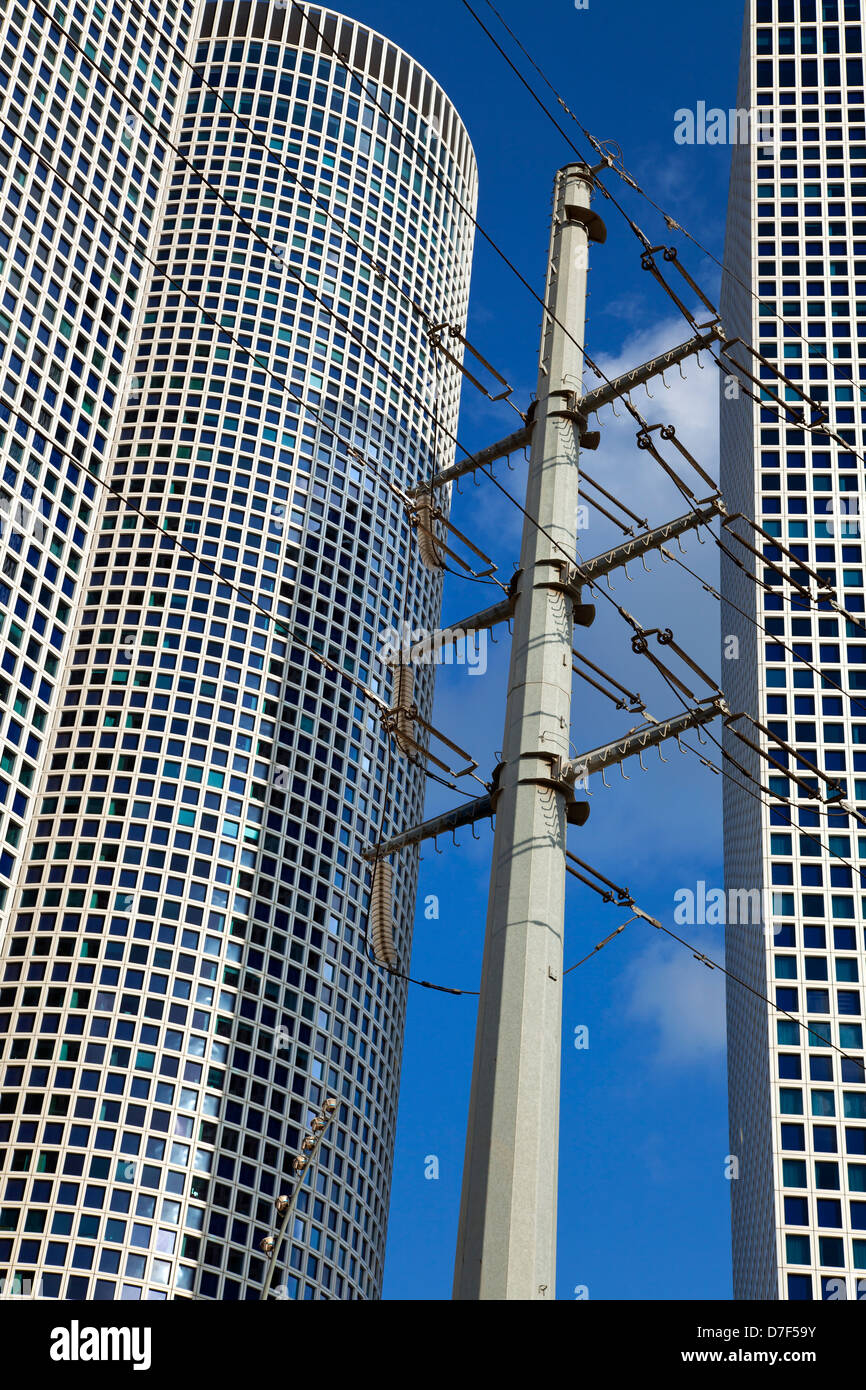 A high voltage electricity pylon located among three skyscrapers in Tel ...