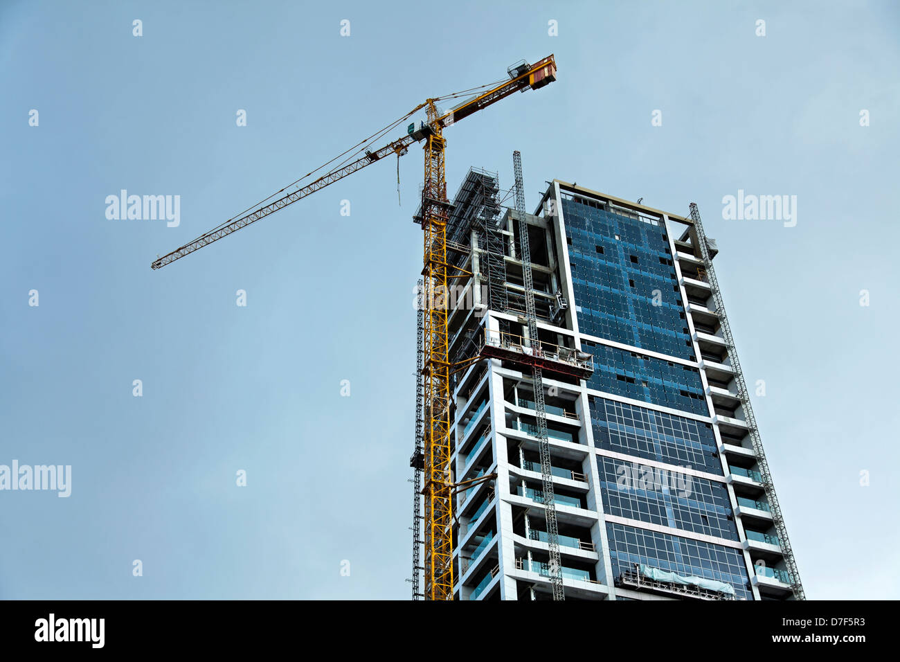 A high rise residential building in the middle of construction, on the ...