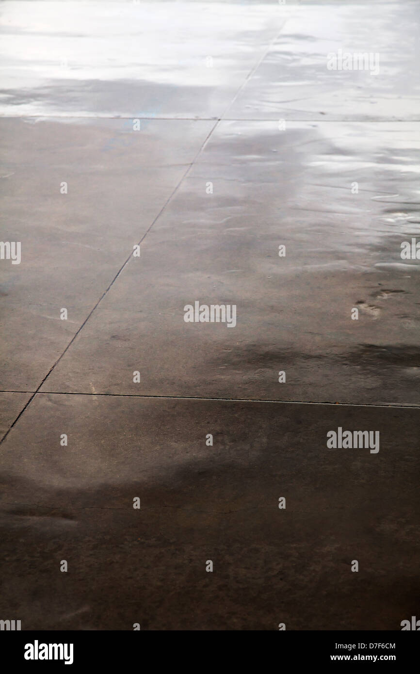 High angle vertical view wet concrete floor reflecting changing ...