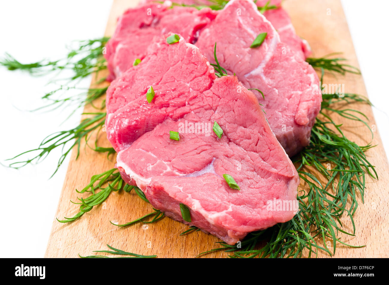 Raw beef with rosemary in white background Stock Photo - Alamy