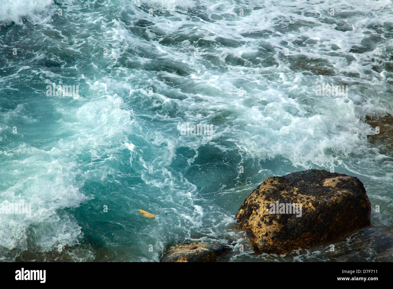 Gushing water with foaming waves smashing against the rocks Stock Photo ...