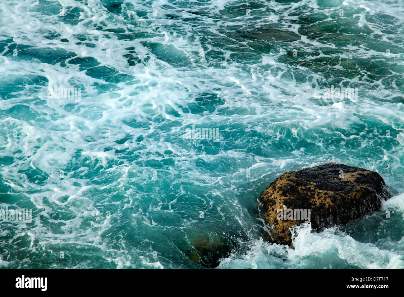 Gushing water with foaming waves smashing against the rocks Stock Photo ...