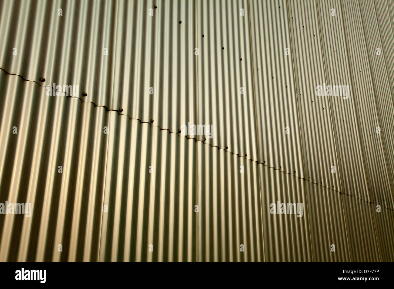 Golden metal squiggly wall in the sunlight. Depicted diagonally Stock ...