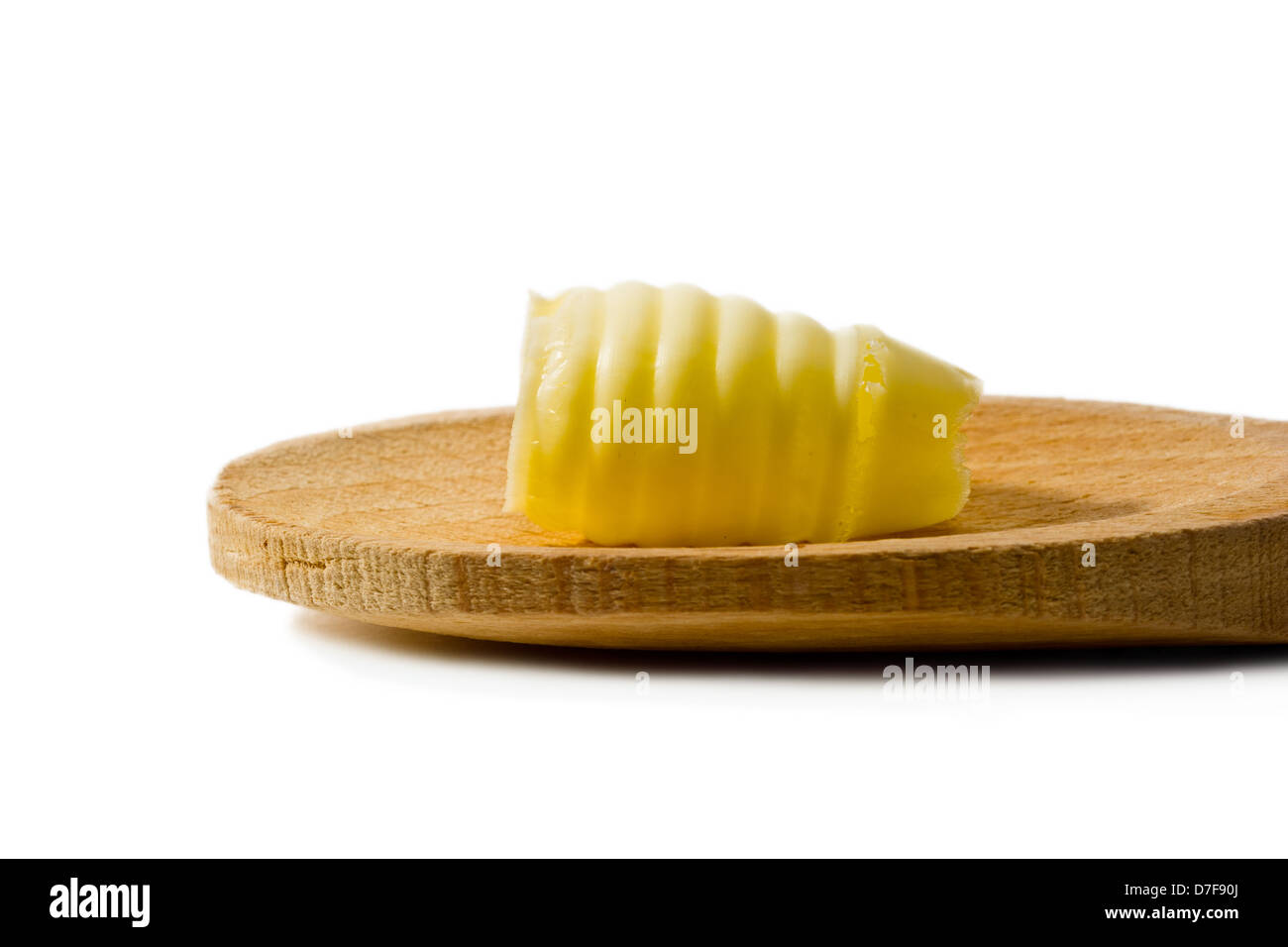 Butter curl on a wooden spoon on white background Stock Photo - Alamy