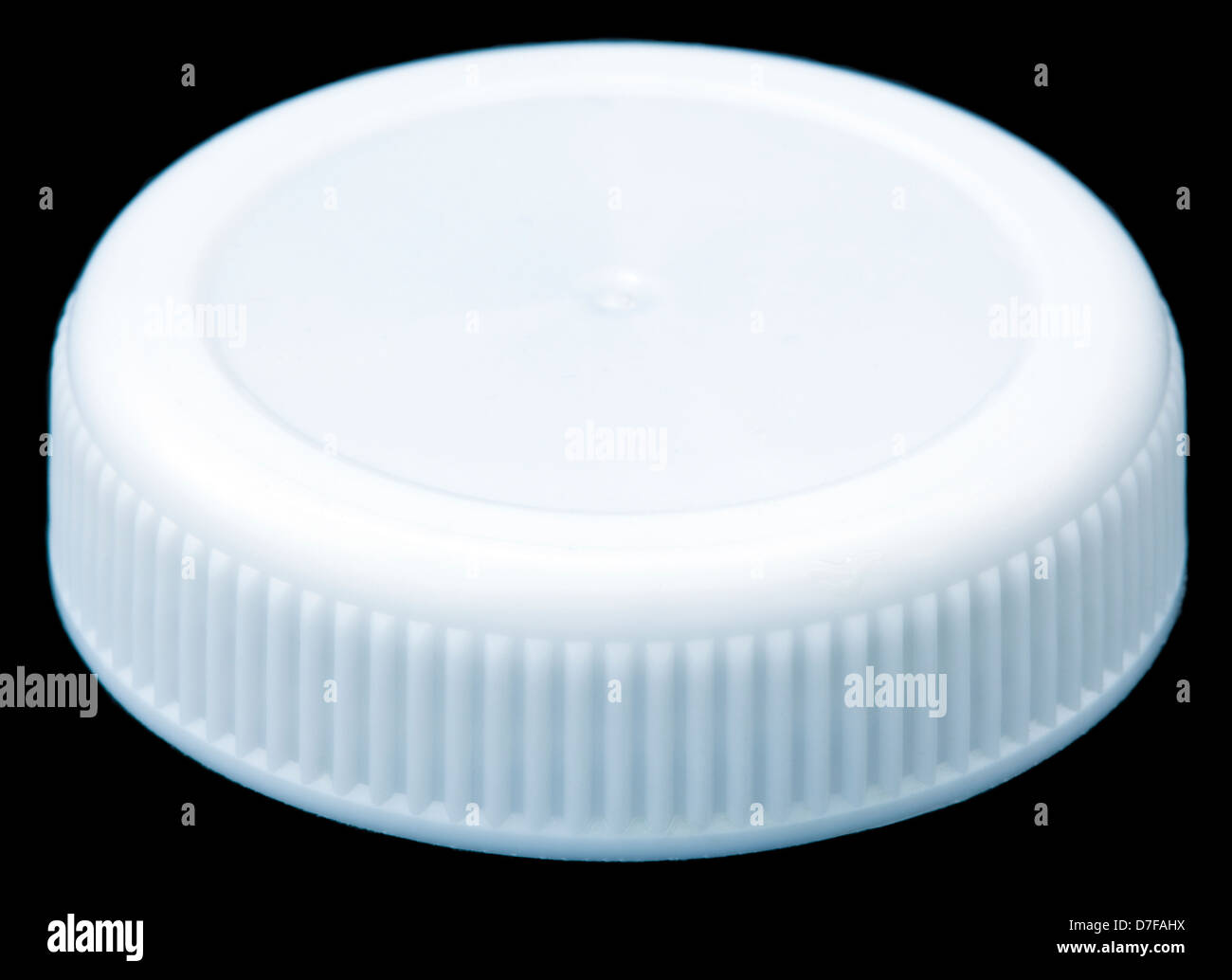 The top side of a white plastic bottle cap seen from a slightly high ...