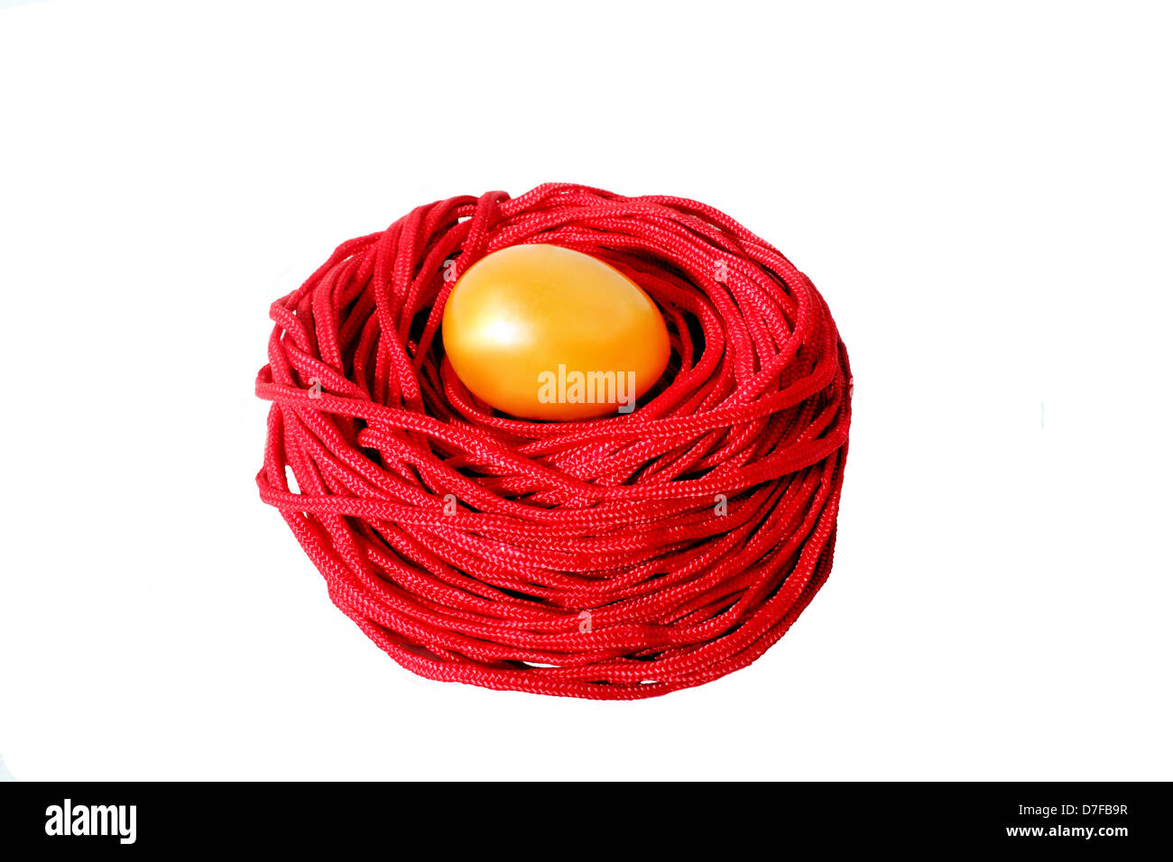 Golden plastic egg shape on a man made nest red plastic rope Stock ...