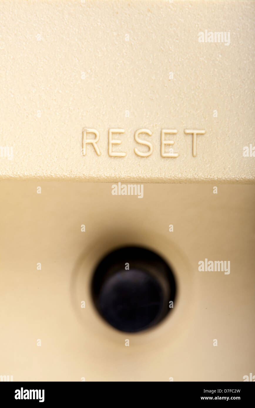 A blurry black plastic button with the writing 'Reset' above it ...