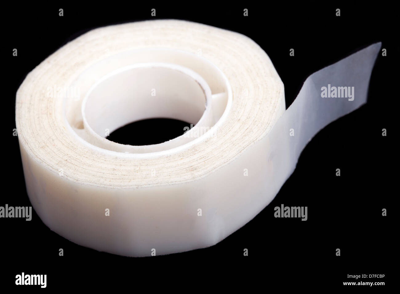 A roll of adhesive tape with dust on it, isolated on black background ...