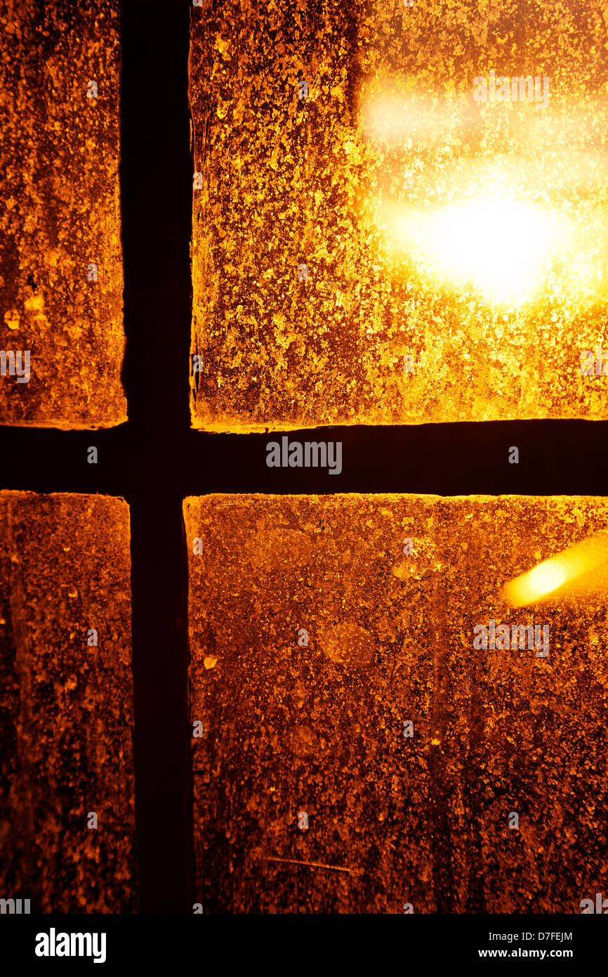 Afternoon yellow sun is back-lighting a window stained with drop marks ...