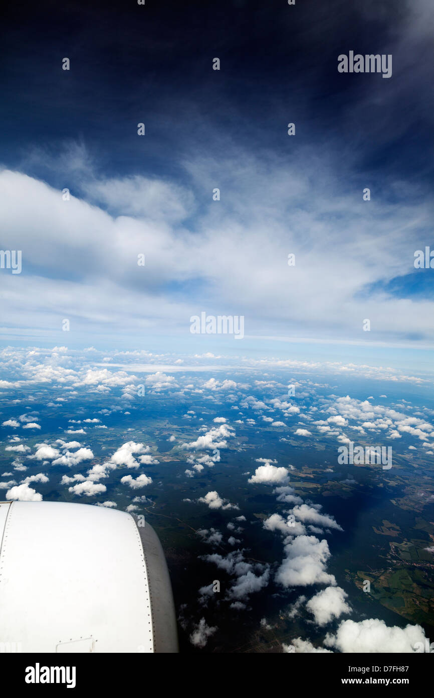 Aerial view of clouds over green land features, with jet engine in the ...